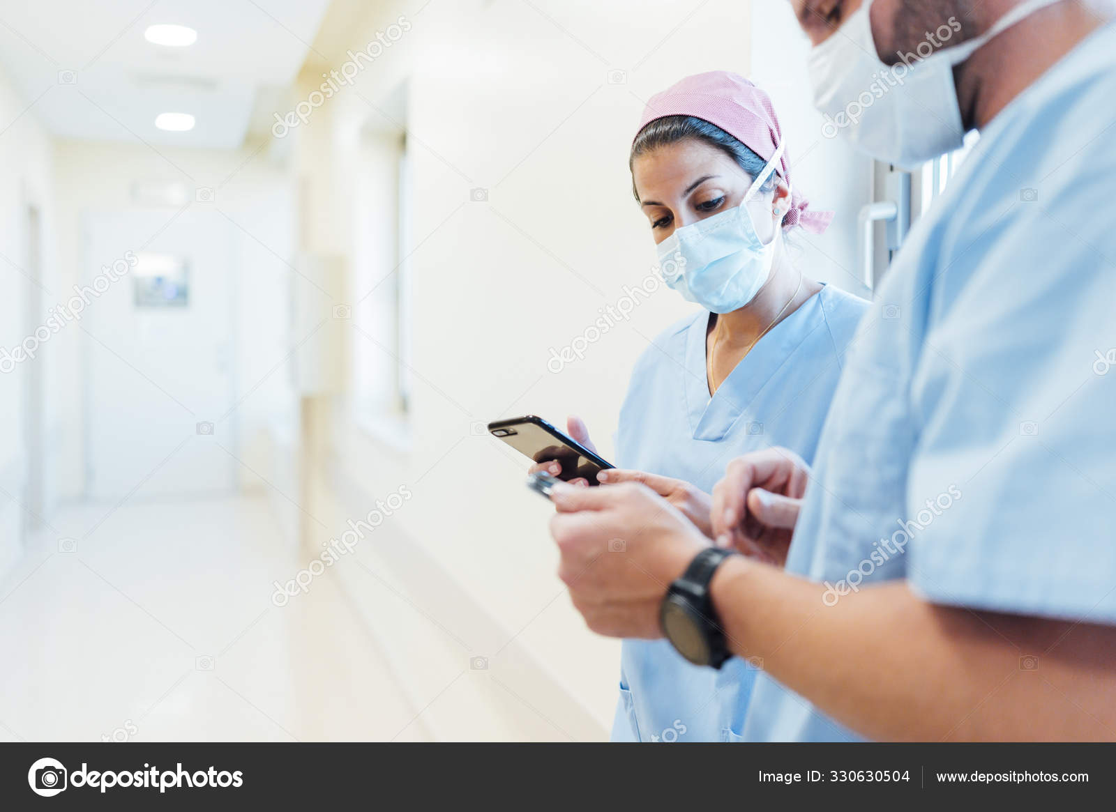 Doctors using cell phones in the hospital corridor. Medical concept ...