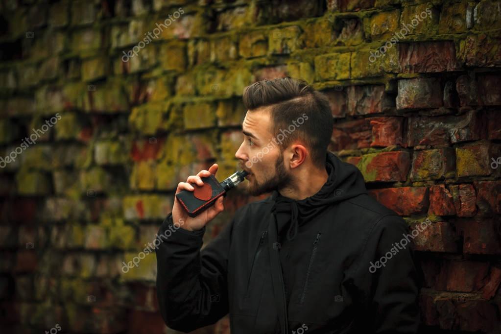 Hombre Vape. Foto de un guapo joven blanco con corte de pelo moderno en ...