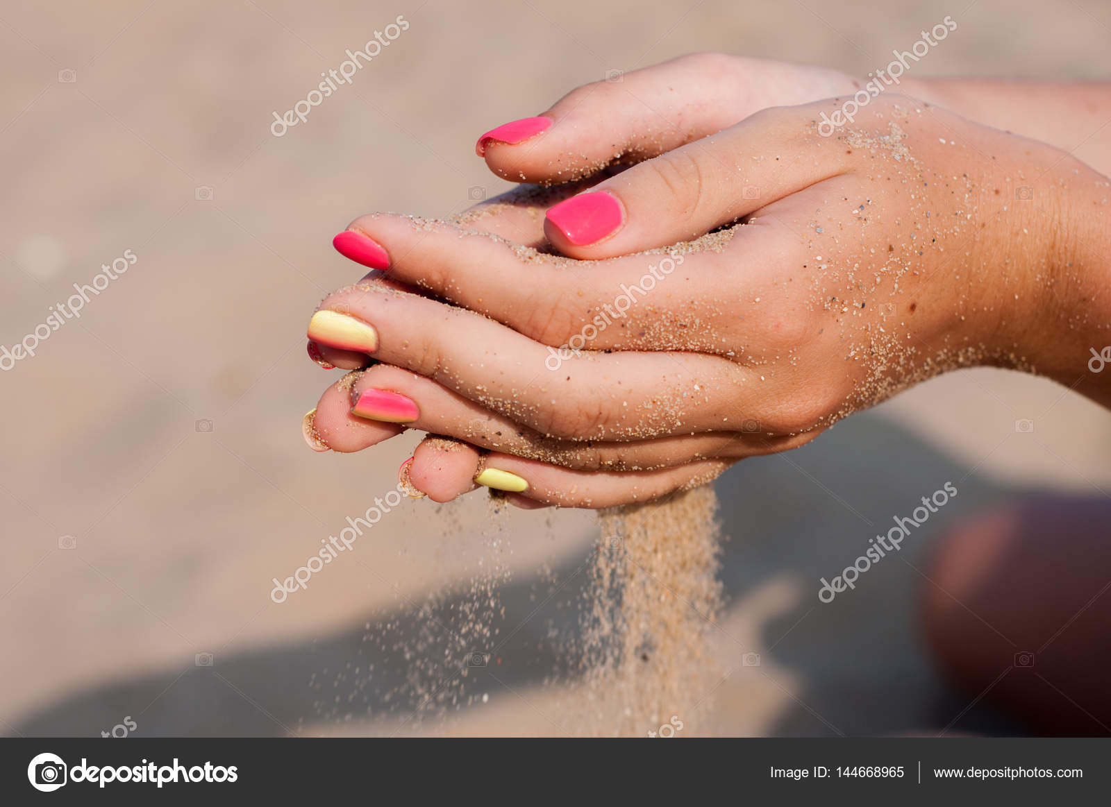 Girl sifting sand through her fingers. Hands close-up Stock Photo by ...