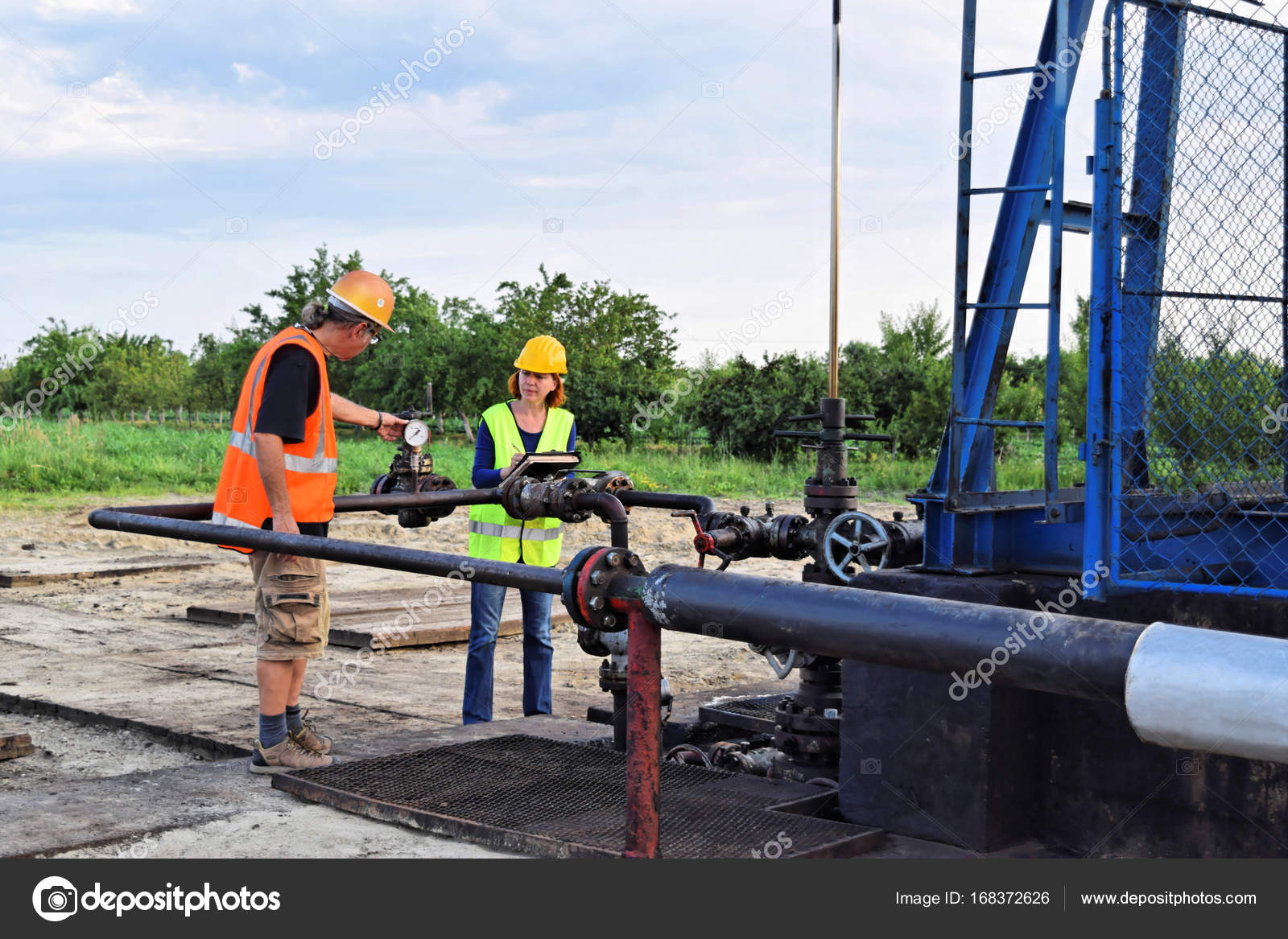 Two petroleum engineers at work on an European oil well Stock Photo by ...