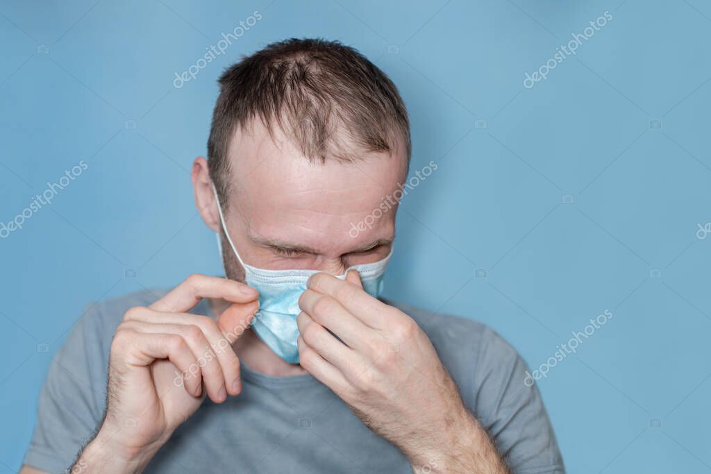 hombre ajusta la máscara protectora en la cara. El hombre sostiene la ...