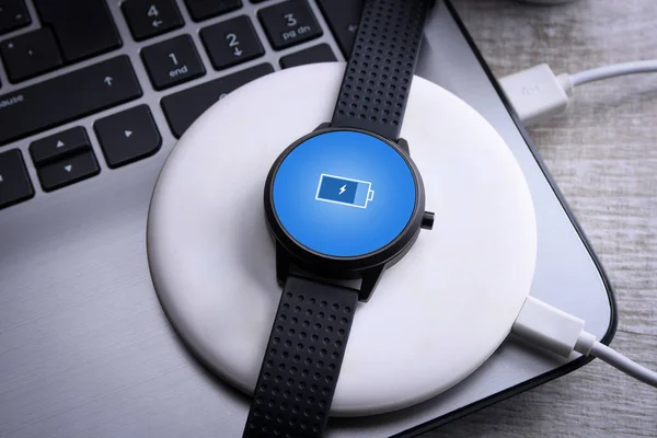 Smart watch on wireless charging with on-screen charging indicator. At ...