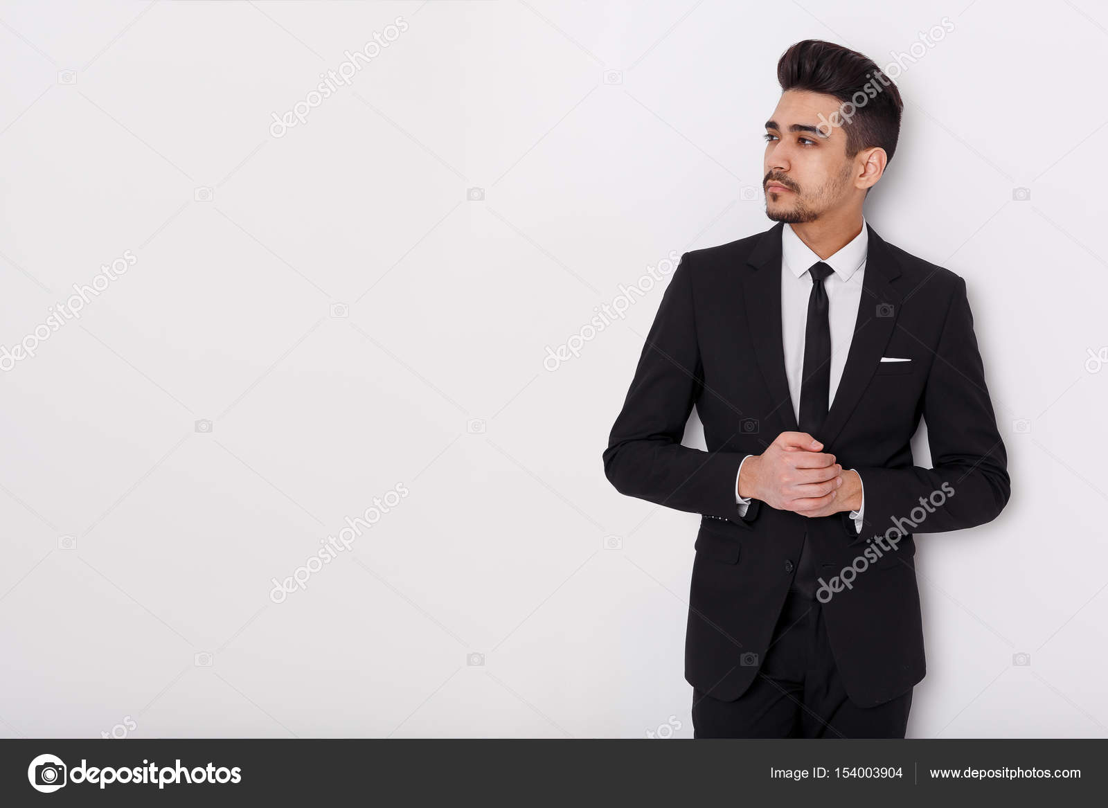 Young businessman in black suit on a white background. Confident man ...