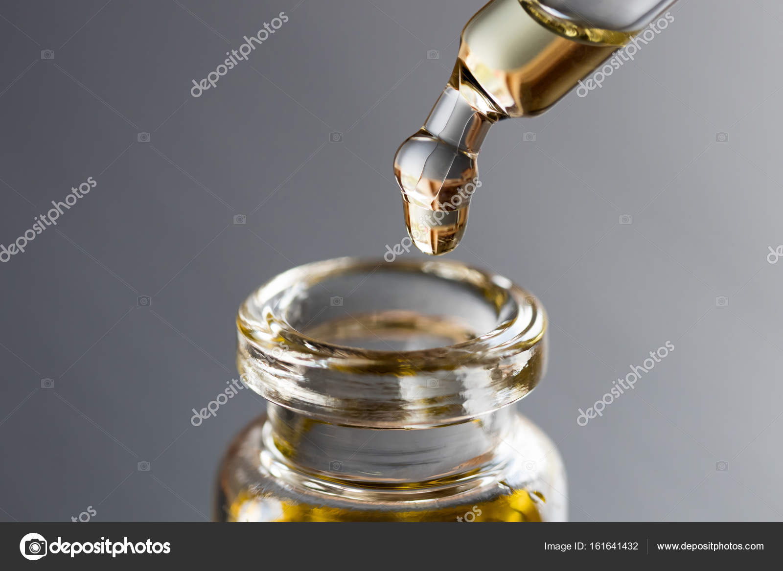 A drop of essential oil is being dropped into a bottle — Stock Photo ...