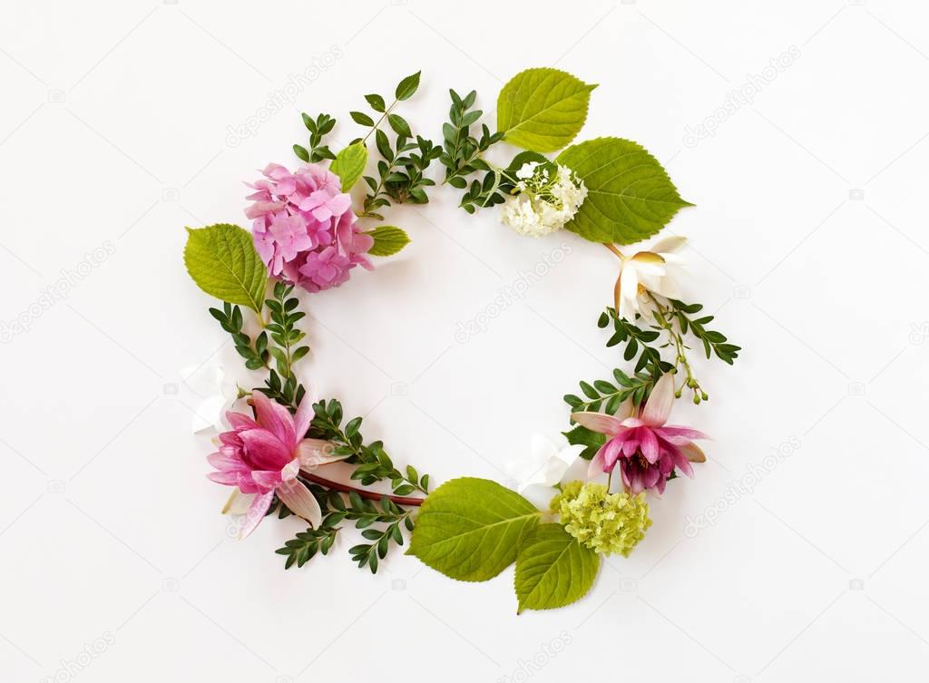 Round frame with blooming flowers and leaves on white background ...