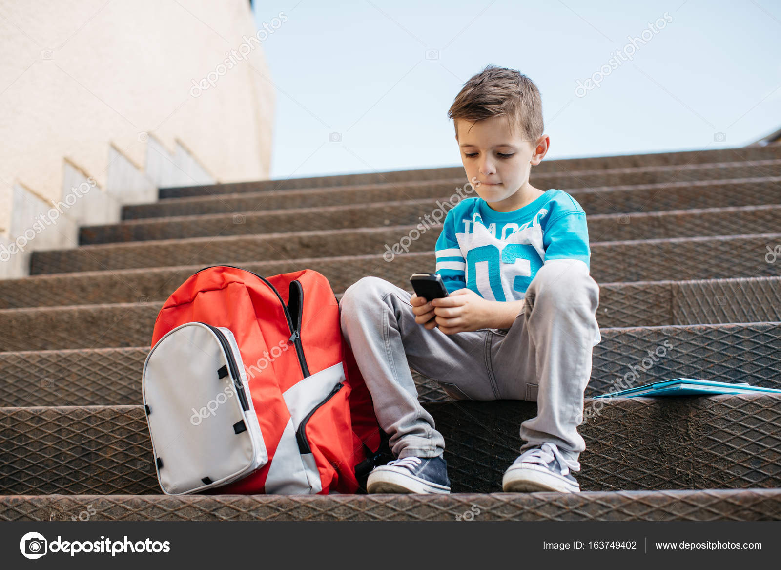Schoolboy taking a break from school and browsing his mobile Stock ...