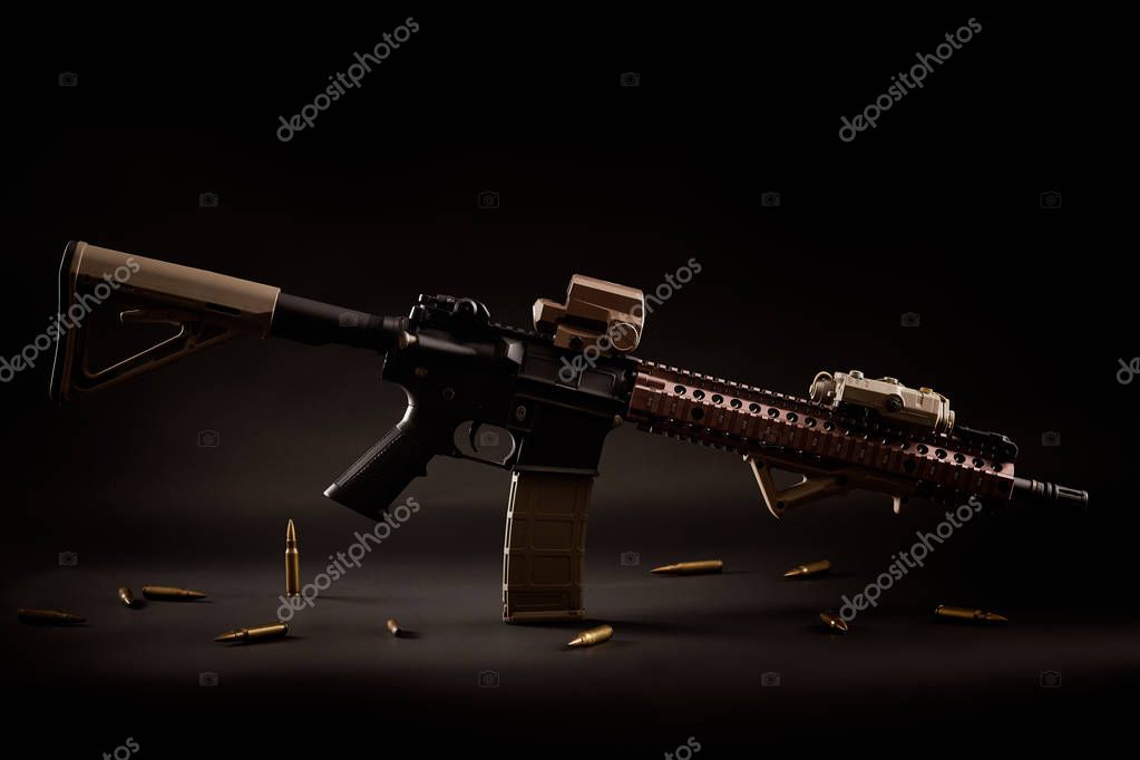 rifle de asalto y balas doradas sobre un fondo negro 2024