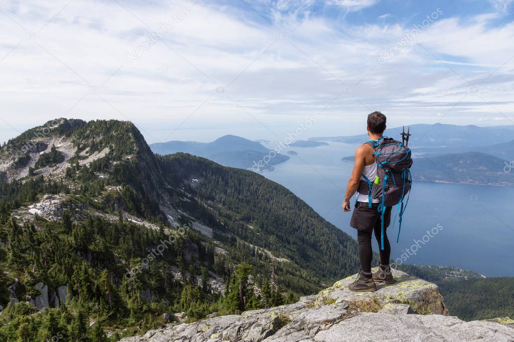 Latin American Male Hiker está de pie en la cima del pico rocoso con ...