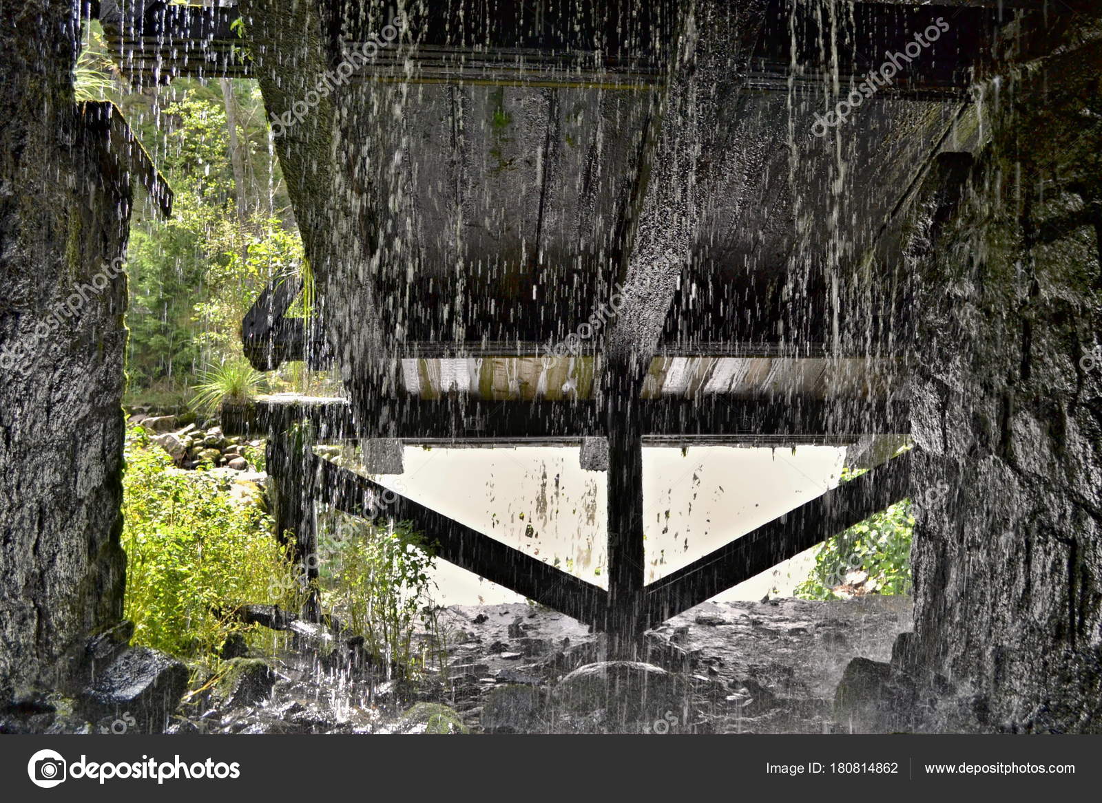 Dripping stream of water at the end of tunnel where is a wooden ...