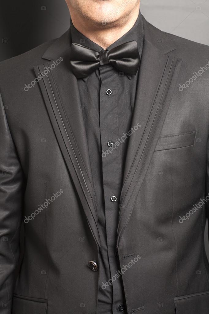 Man Wearing A Black Suit And Bow Tie On Gray Background Stock Photo By ...