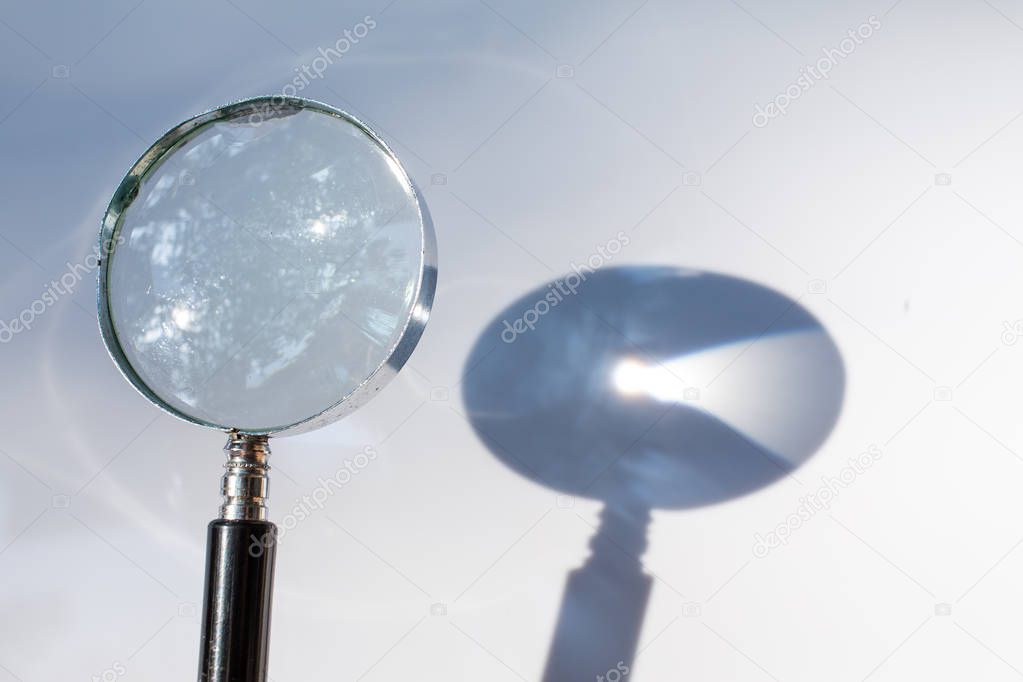 Lupa antigua aislada sobre fondo blanco, luz y sombra 2024