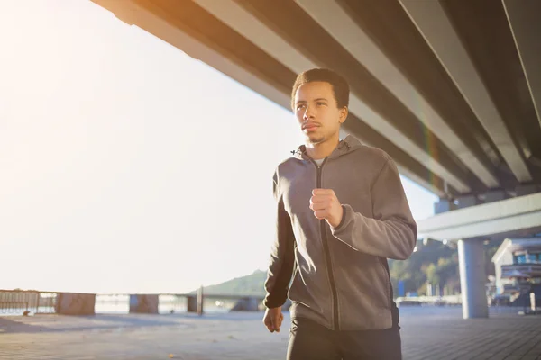 Young fit man running at outdoors, autumn , attractive dark skinned ...