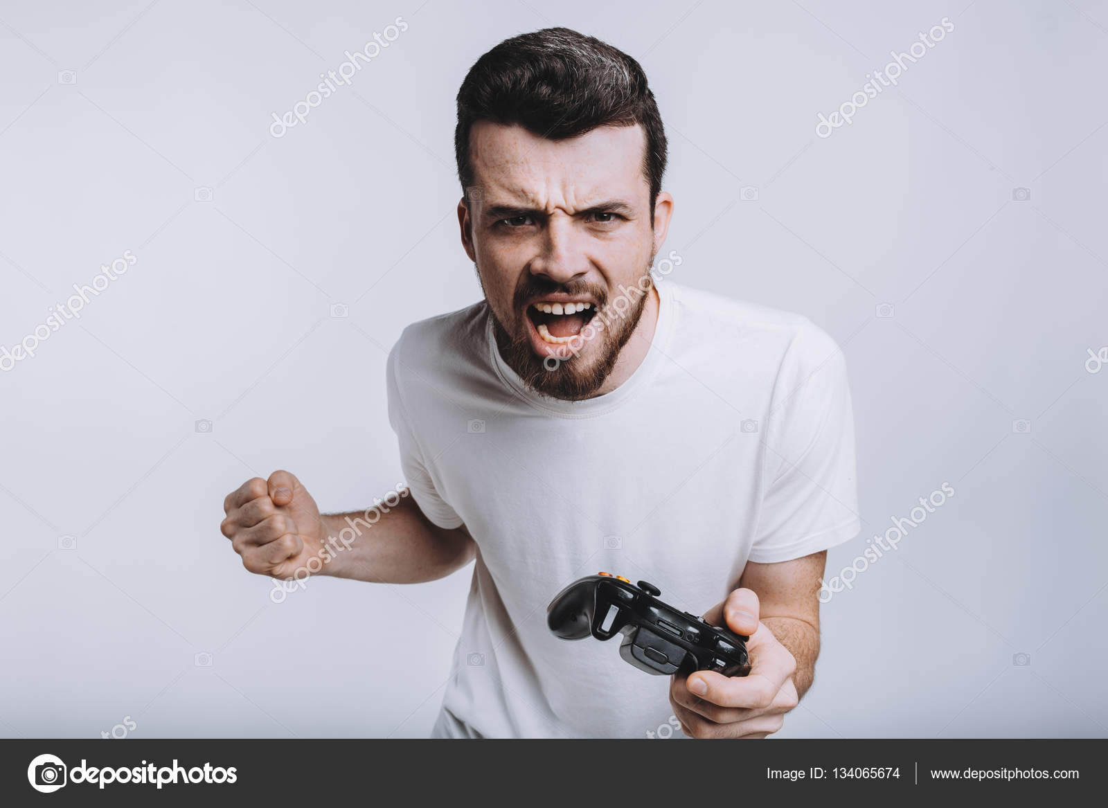 Young guy with beard holding joystick pretending he is playing games ...