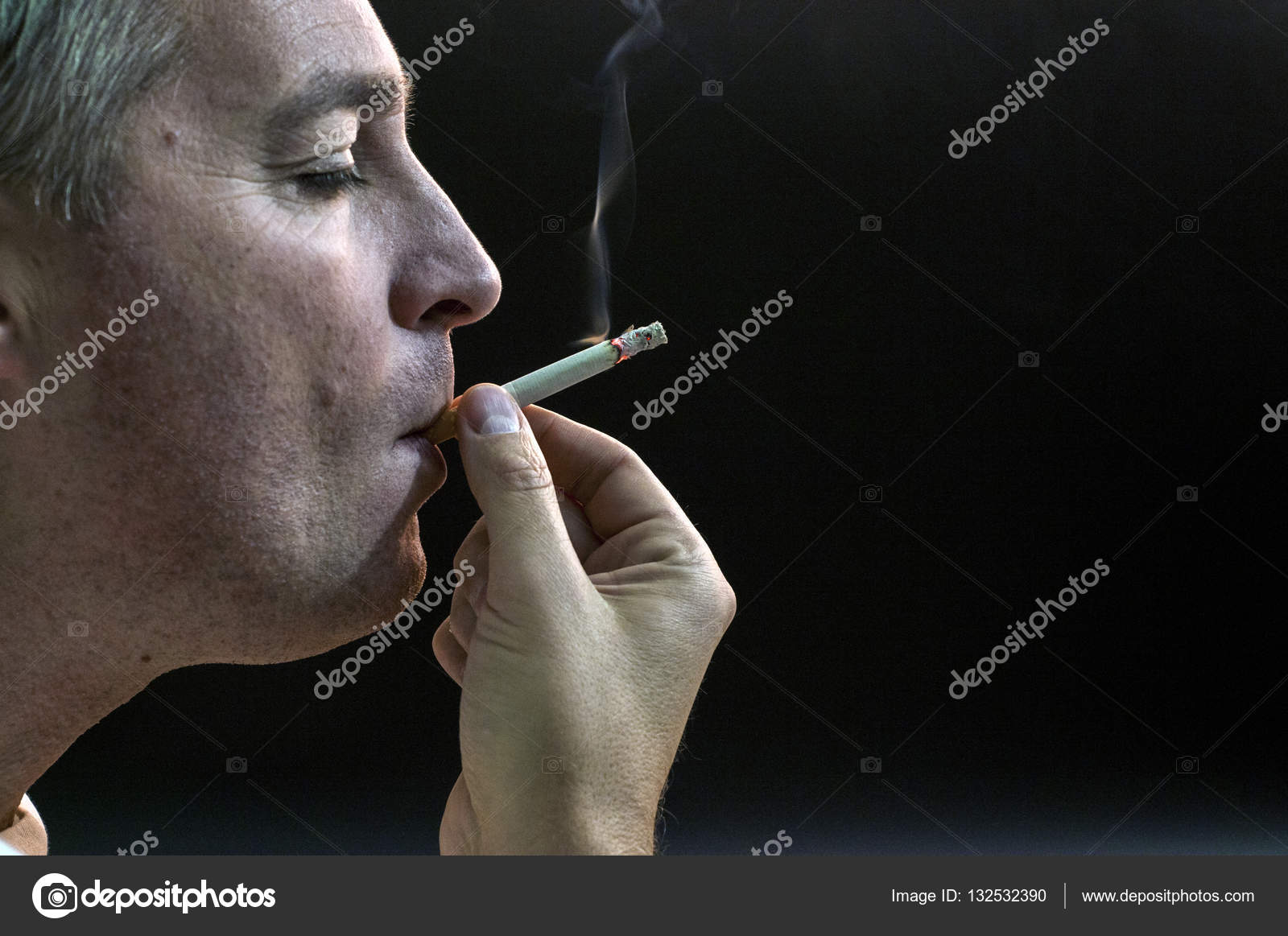Homem fumando cigarro no fundo preto, Bonito jovem fumando cigarro ...