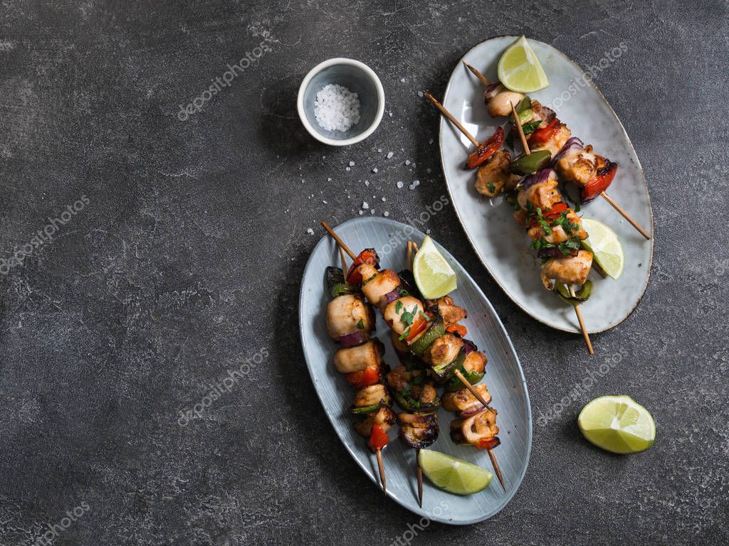 Pollo sobre pinchos en plato ovalado y ensalada fresca con verduras ...