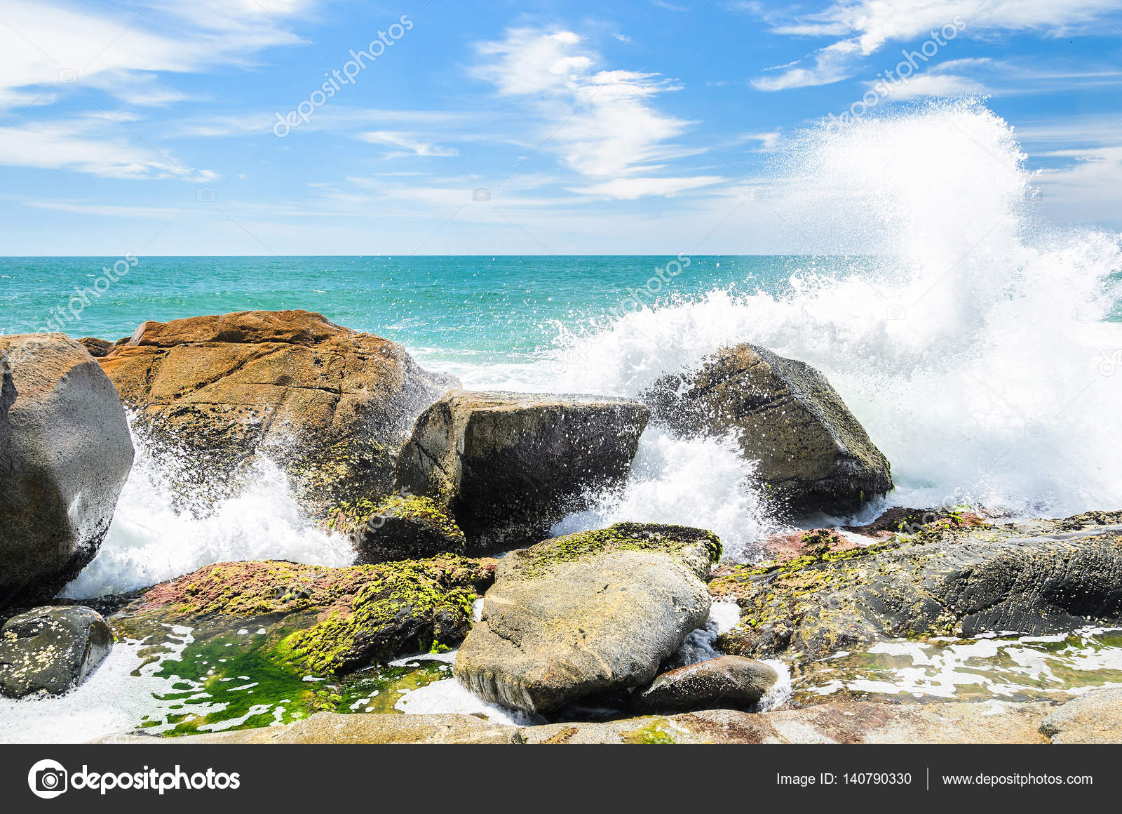 Sea water hitting into rocks on coast and splashing water drops ...