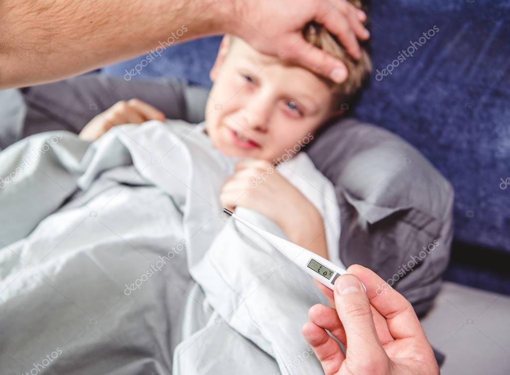 Little boy has a fever — Stock Photo © ArturVerkhovetskiy #134908924
