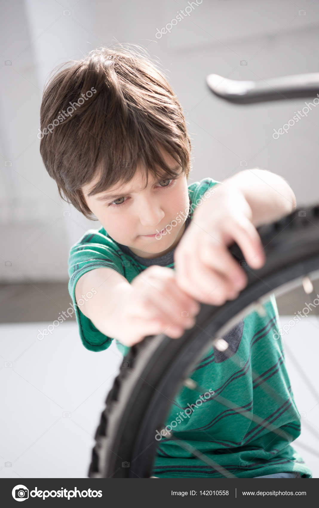 Boy checking bicycle tyre — Stock Photo © ArturVerkhovetskiy #142010558