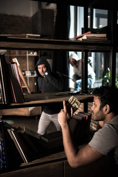 Scared man hiding from burglar Stock Photo by ©ArturVerkhovetskiy 150248622