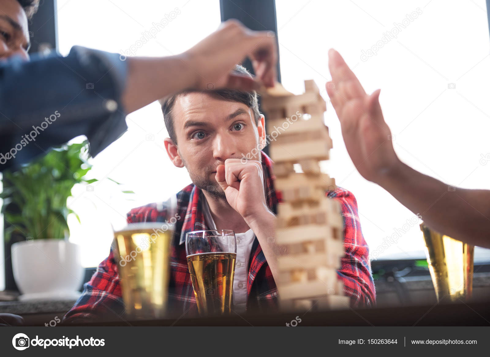 Men playing jenga game — Stock Photo © ArturVerkhovetskiy #150263644