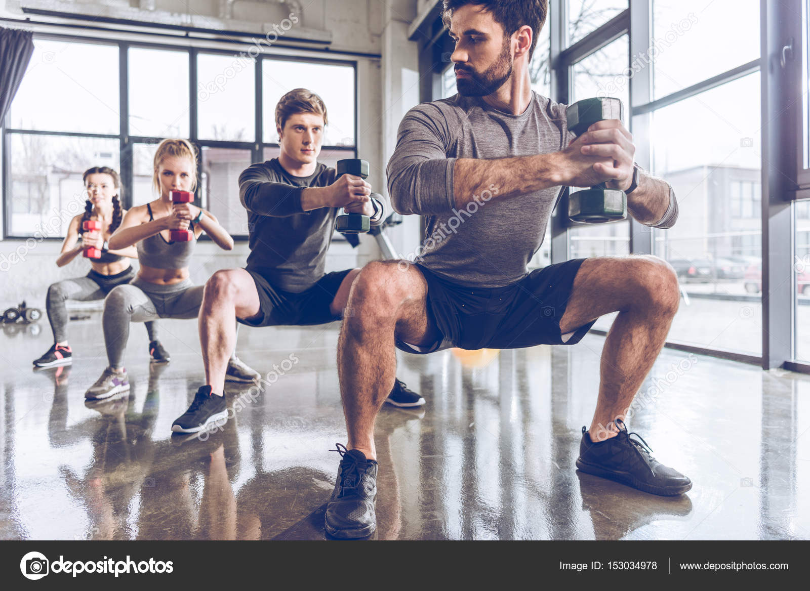 Sporty people exercising in gym Stock Photo by ©ArturVerkhovetskiy ...