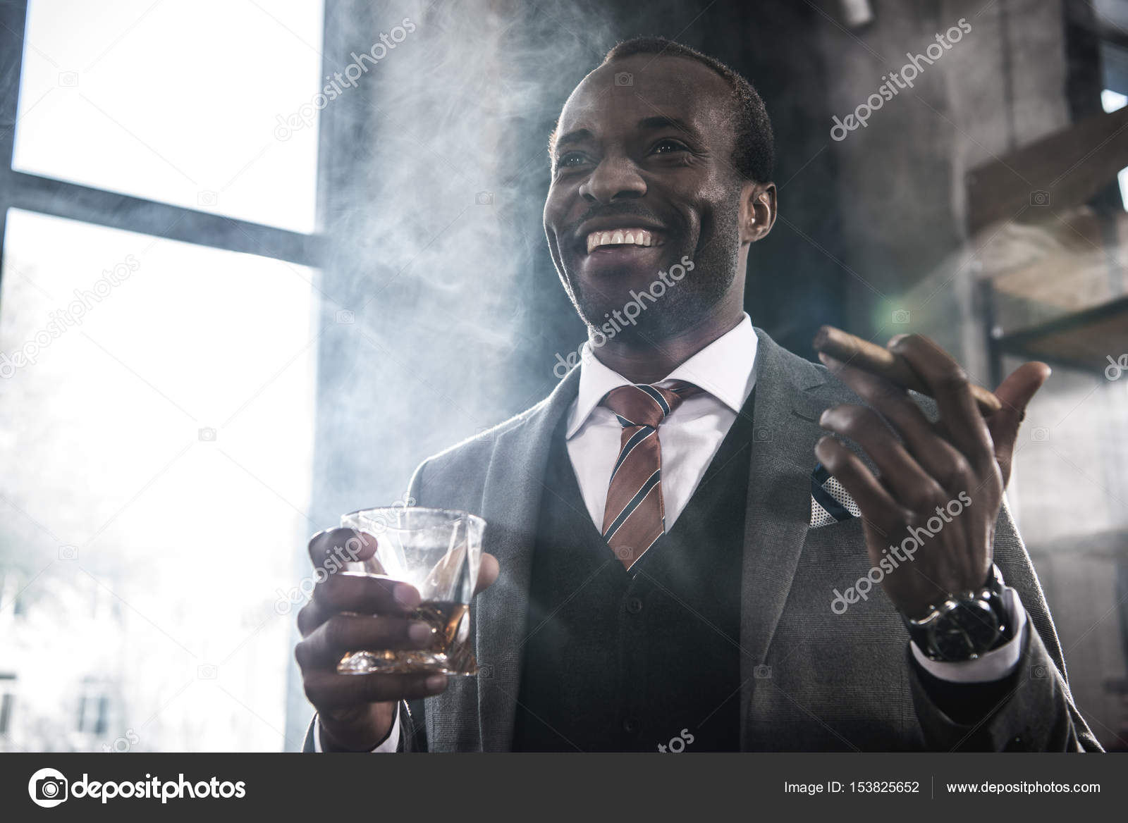 Smiling African American Businessman Holding Glass With Whiskey And