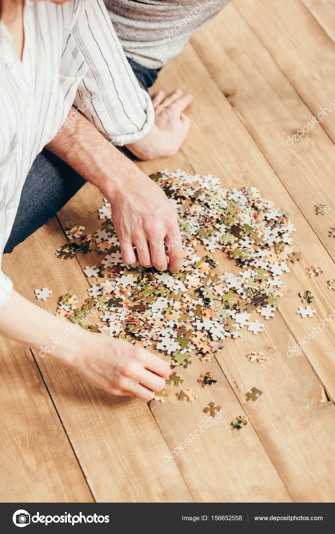 Couple collecting puzzle on wooden floor — Stock Photo ...