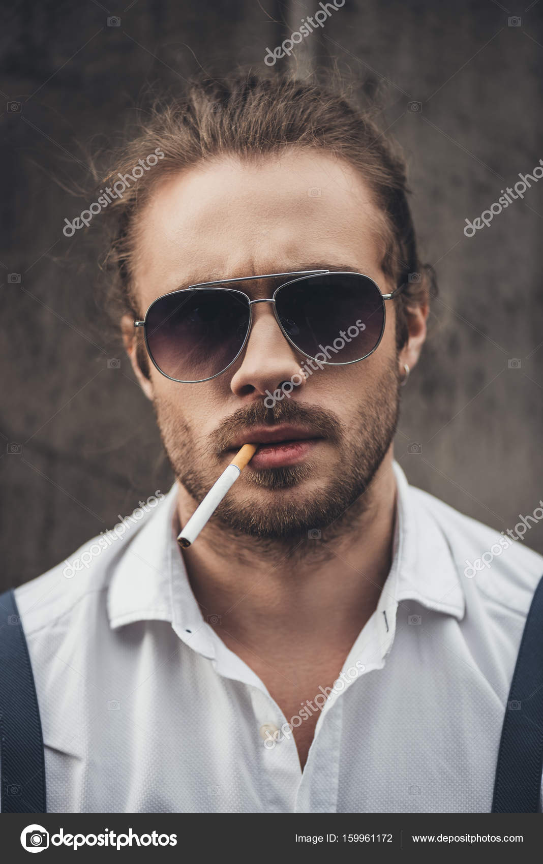 Stylish young man smoking — Stock Photo © ArturVerkhovetskiy #159961172
