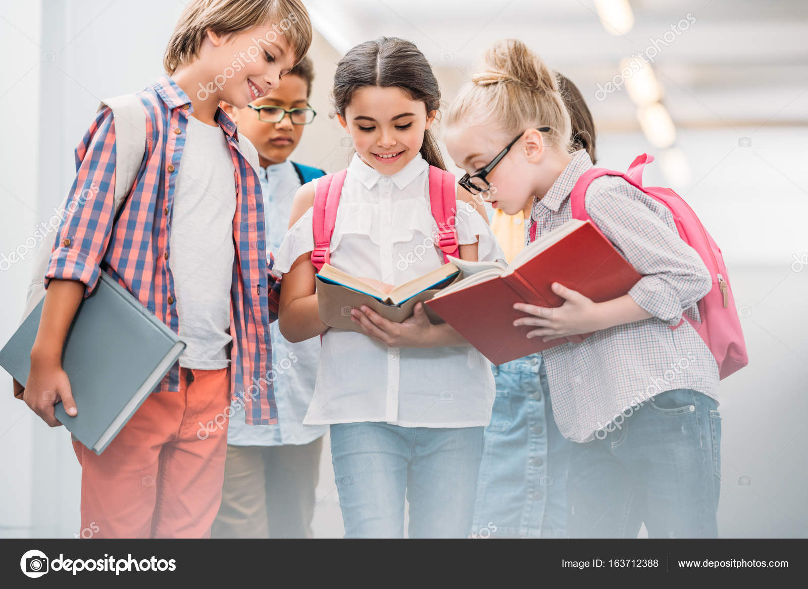 Happy scholars looking at book — Stock Photo © ArturVerkhovetskiy ...