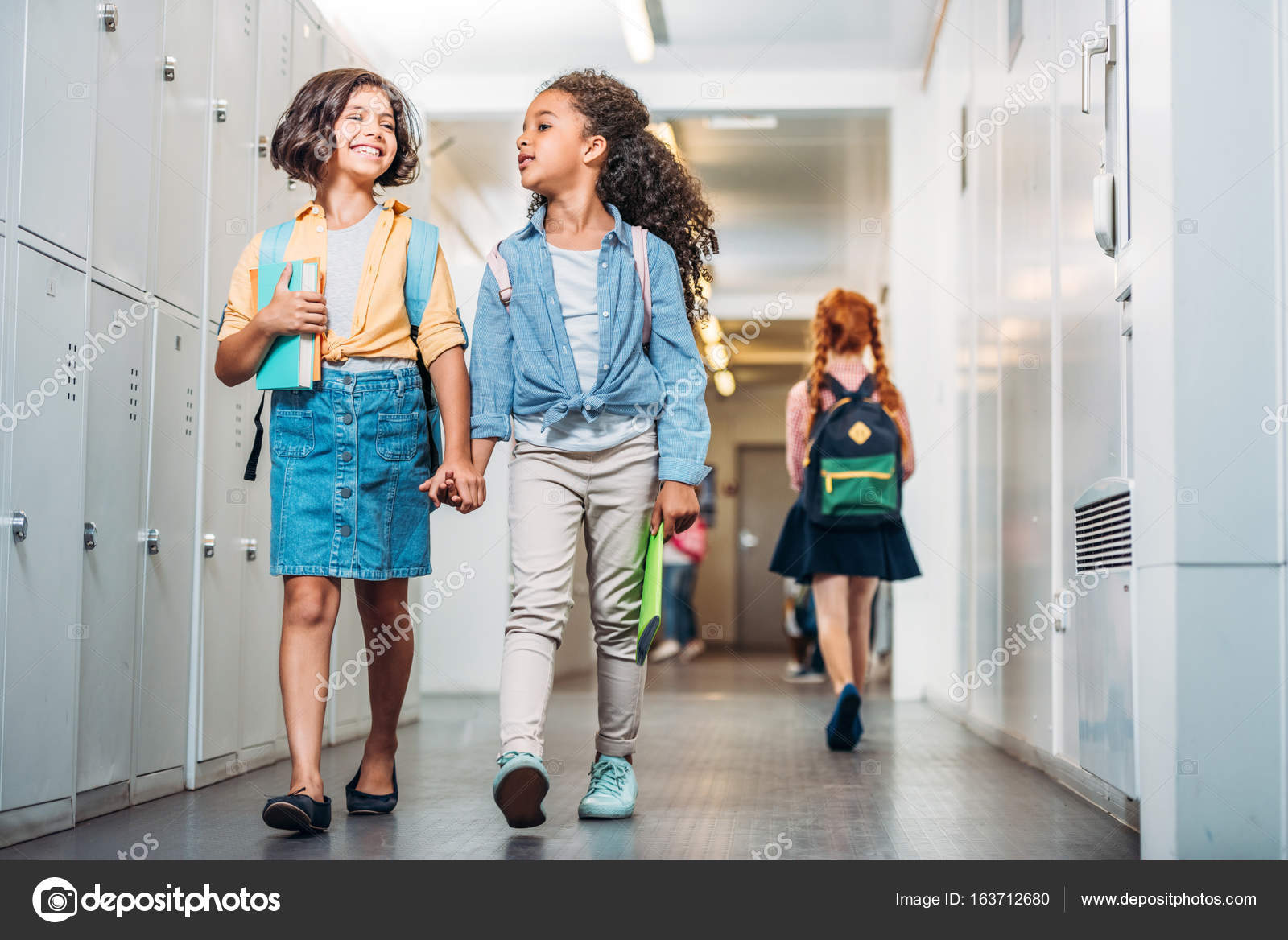 Girls walking through school corridor — Stock Photo ...