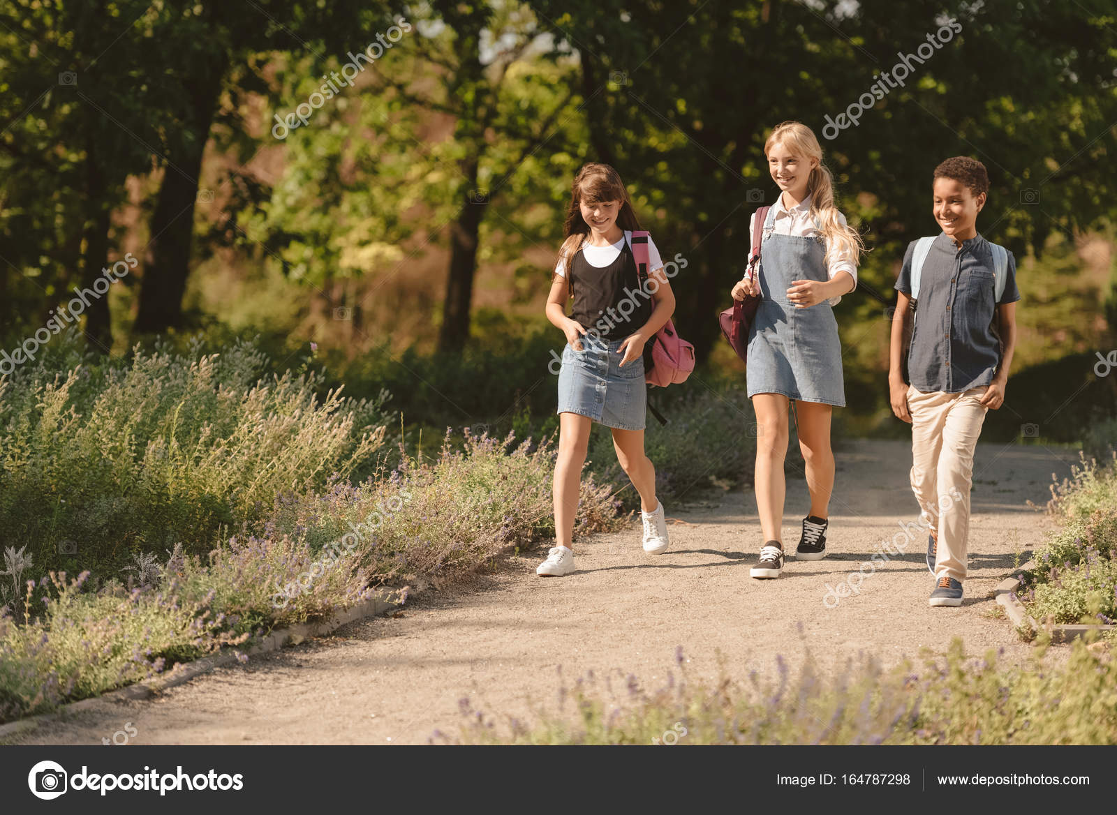Multiethnic teens walking in park — Stock Photo © ArturVerkhovetskiy ...