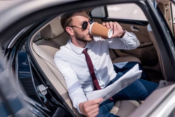 Businessman drinking coffee in car - Stock Image - Everypixel