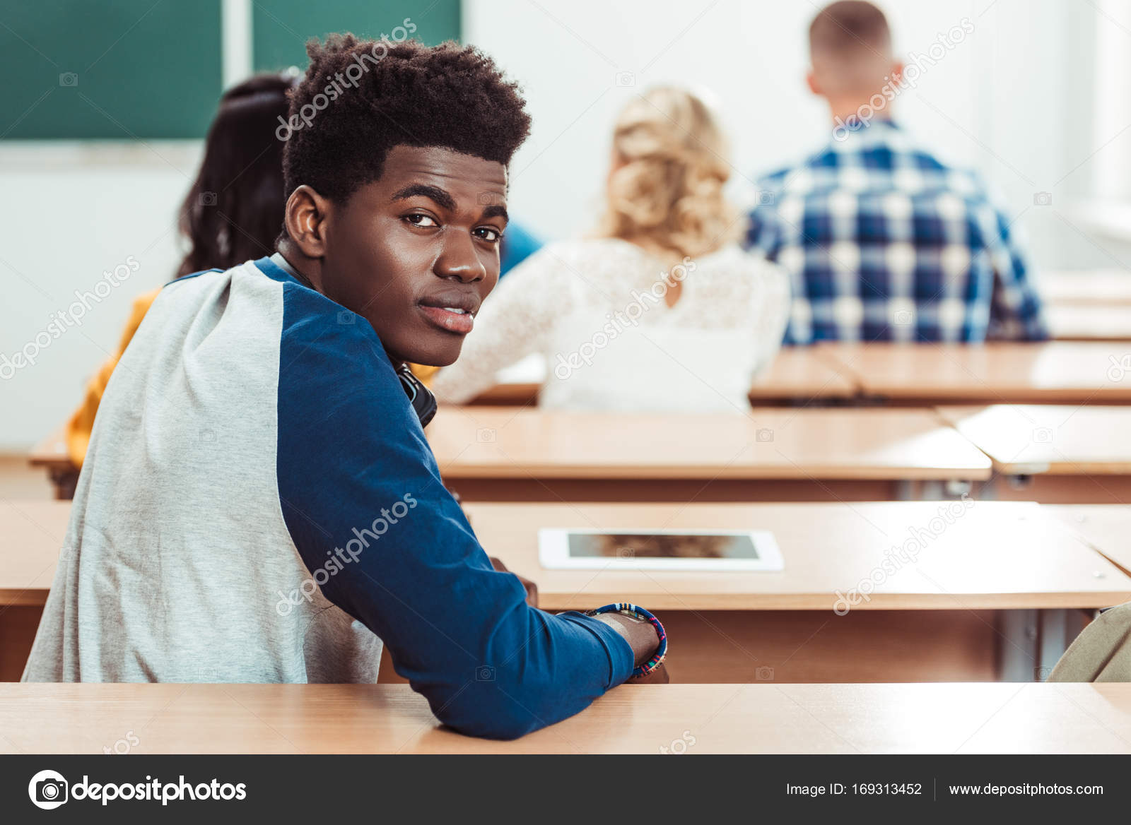 Student sitting in classroom — Stock Photo © ArturVerkhovetskiy #169313452
