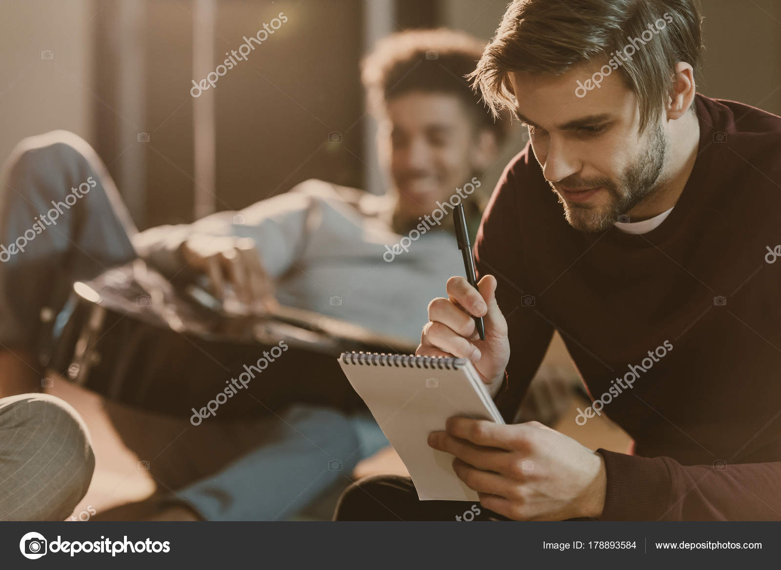 Handsome Young Man Writing Lyrics Notepad While His Friend Lying ...