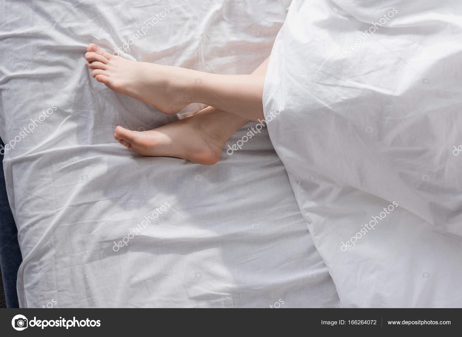 Female feet stretching out of blanket Stock Photo by ©DmitryPoch 166264072