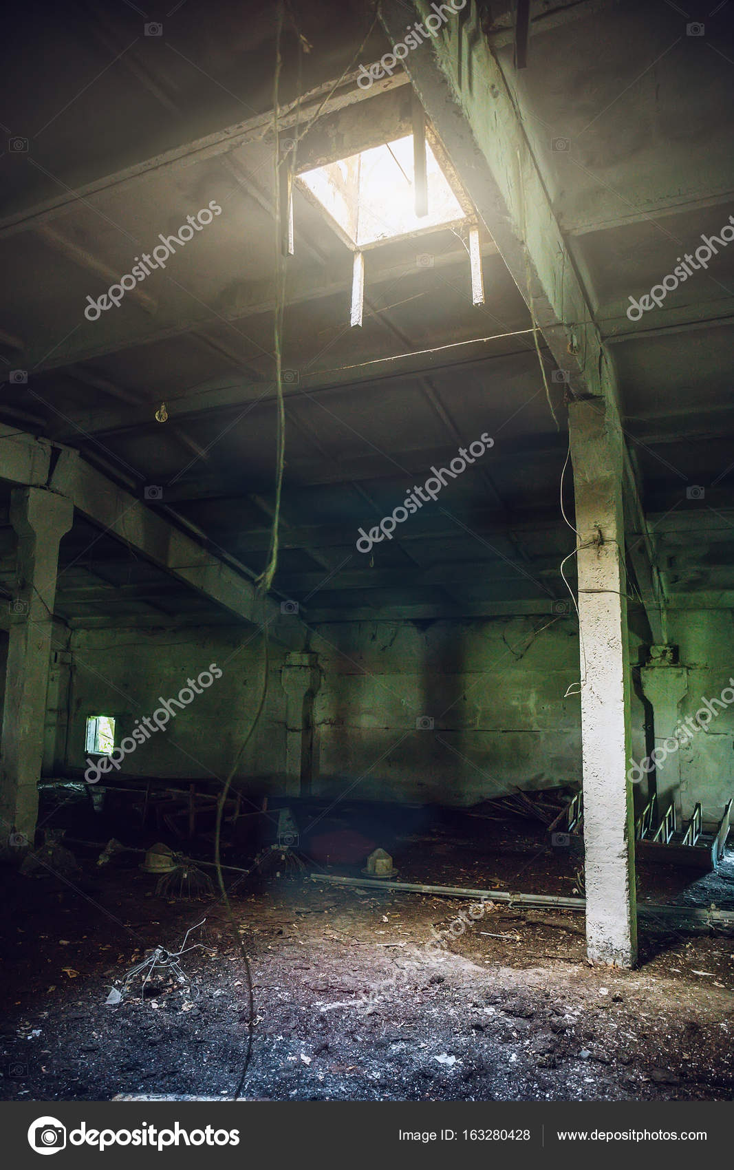 Big dark empty abandoned warehouse room with window in the ceiling and ...