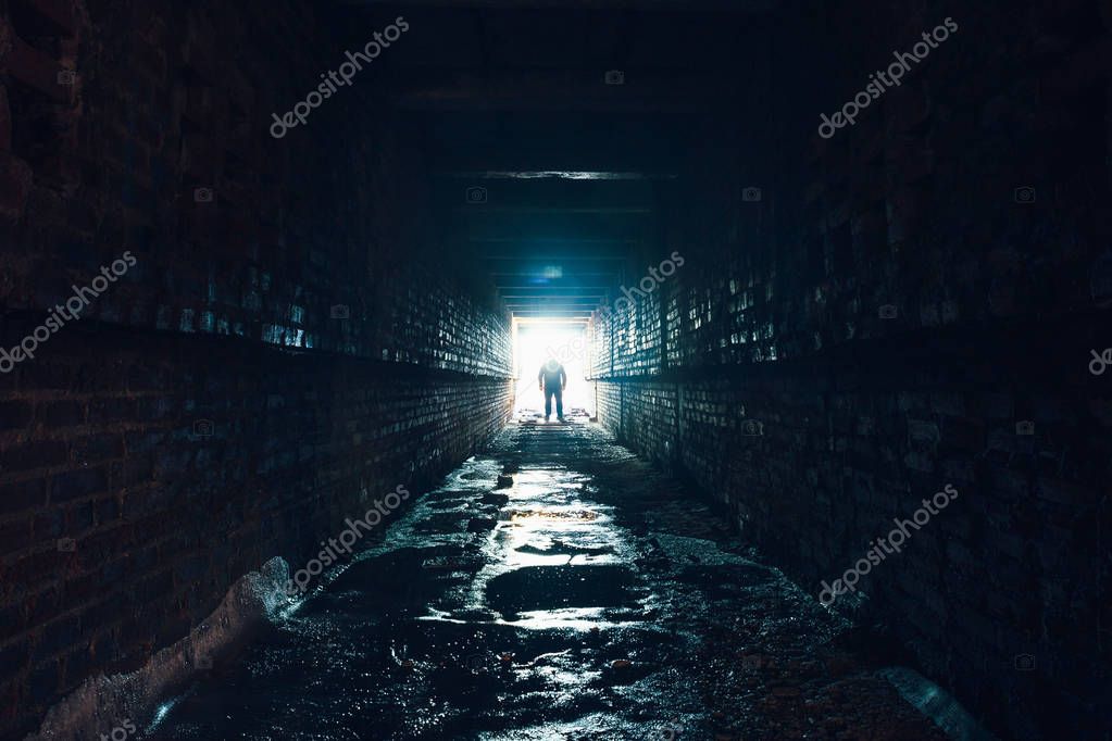 Silueta de hombre de pie en oscuro corredor subterr neo. Luz al final del concepto de t nel 2024