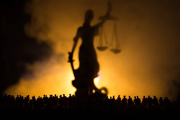 Silhouette of blurred giant lady justice statue with sword and scale ...