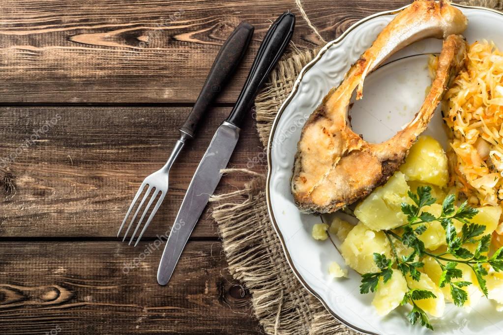 Pescado frito con ensalada y patatas, cena tradicional en plato ...