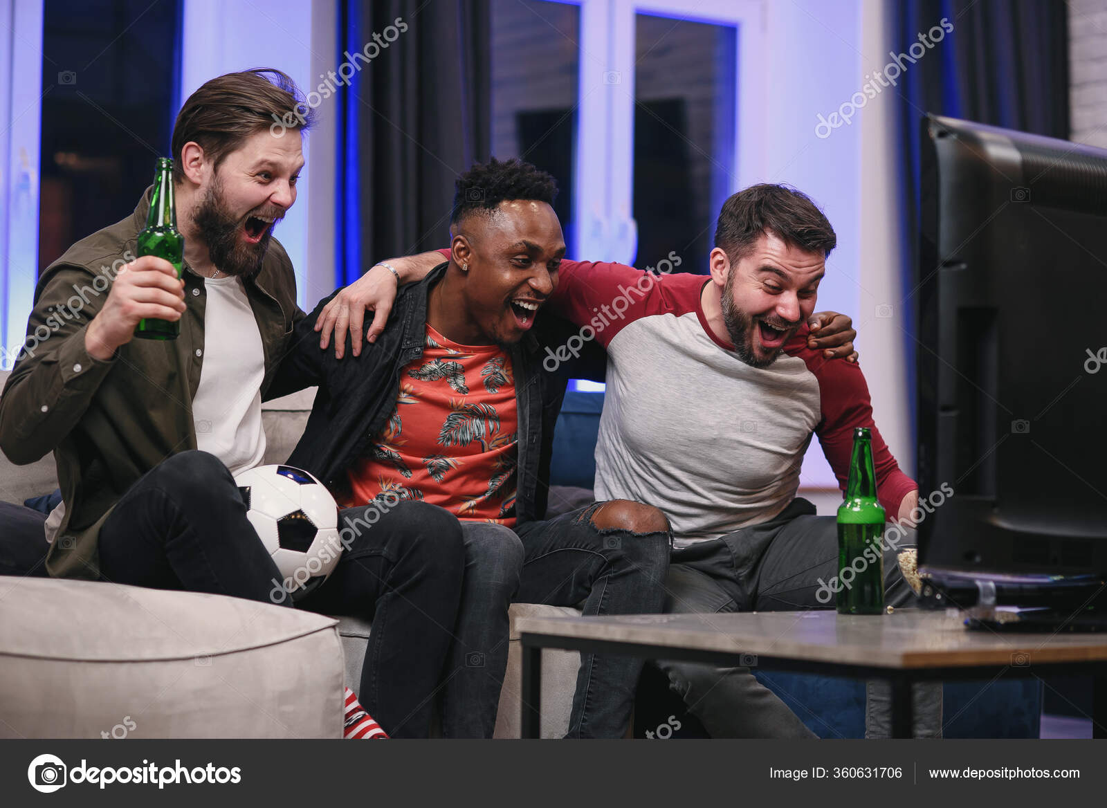 Likable joyful multiracial young guys cheering their favourite football ...