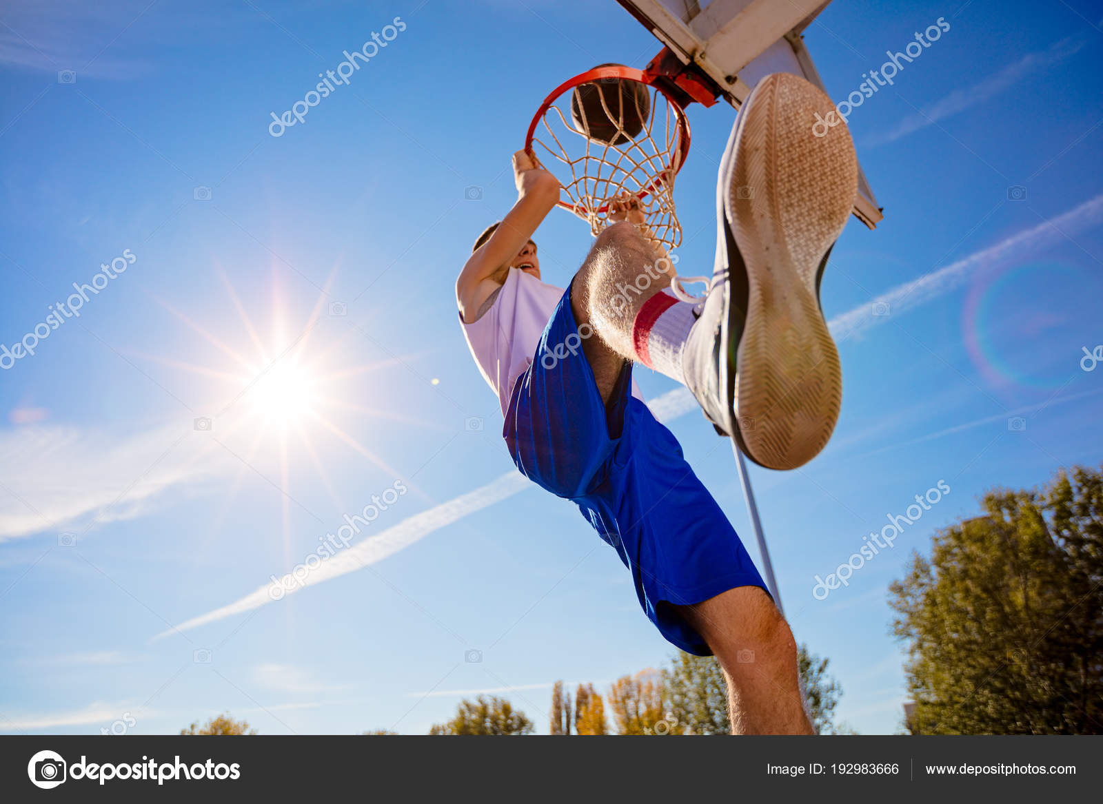 Slam Dunk. Side view of young basketball player making slam dunk ...