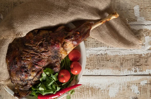 roasted meat leg of lamb baked whole lies with fresh tomato greens and ...