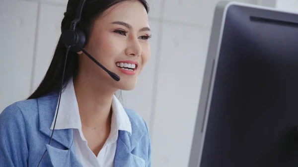 Customer support agent or call center with headset works on desktop ...