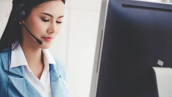 Customer support agent or call center with headset works on desktop ...
