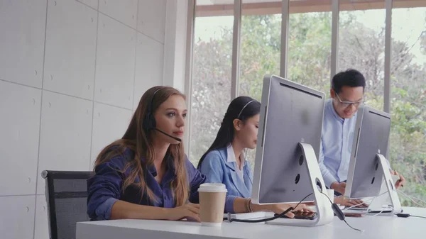 Customer support agent or call center with headset works on desktop ...