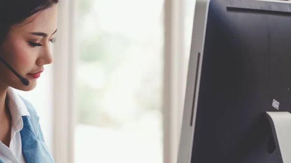 Customer support agent or call center with headset works on desktop ...